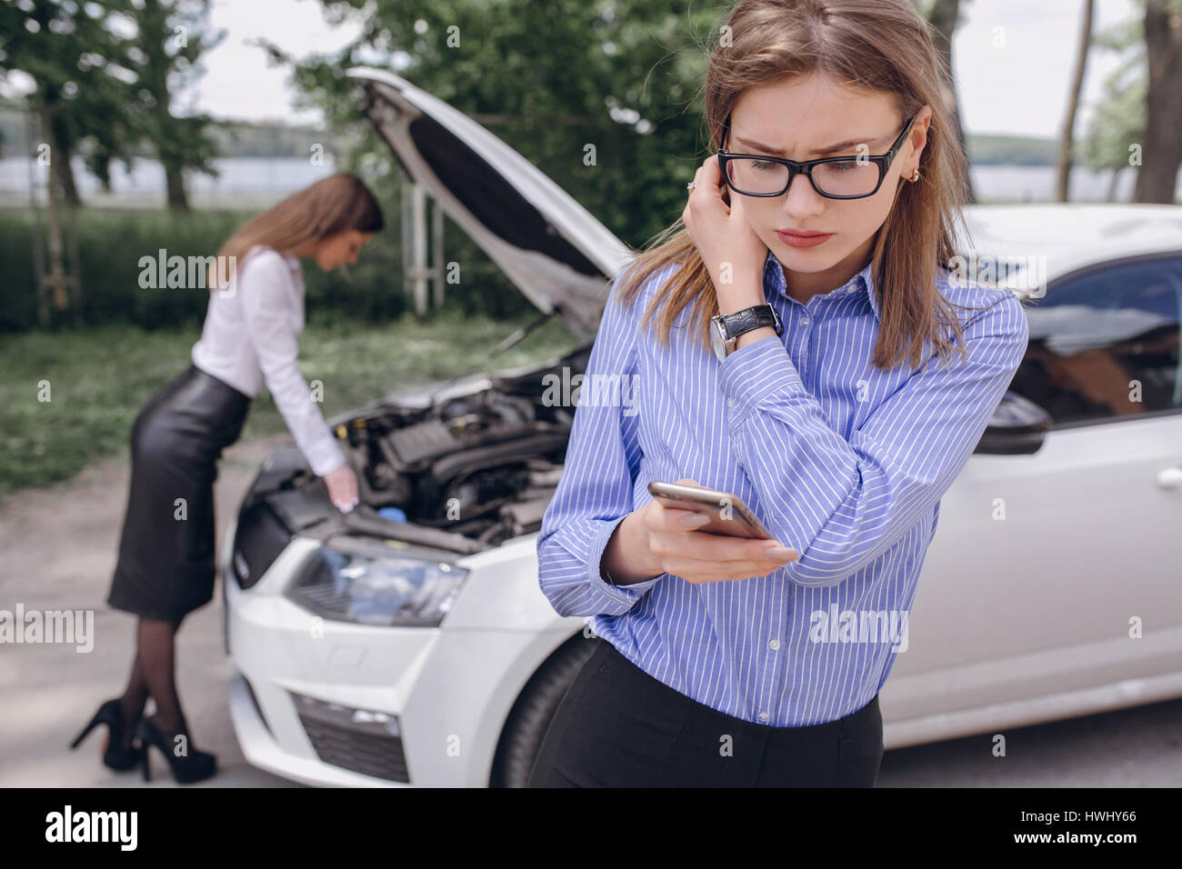 two girls on the road trying to fix their car Stock Photo - Alamy