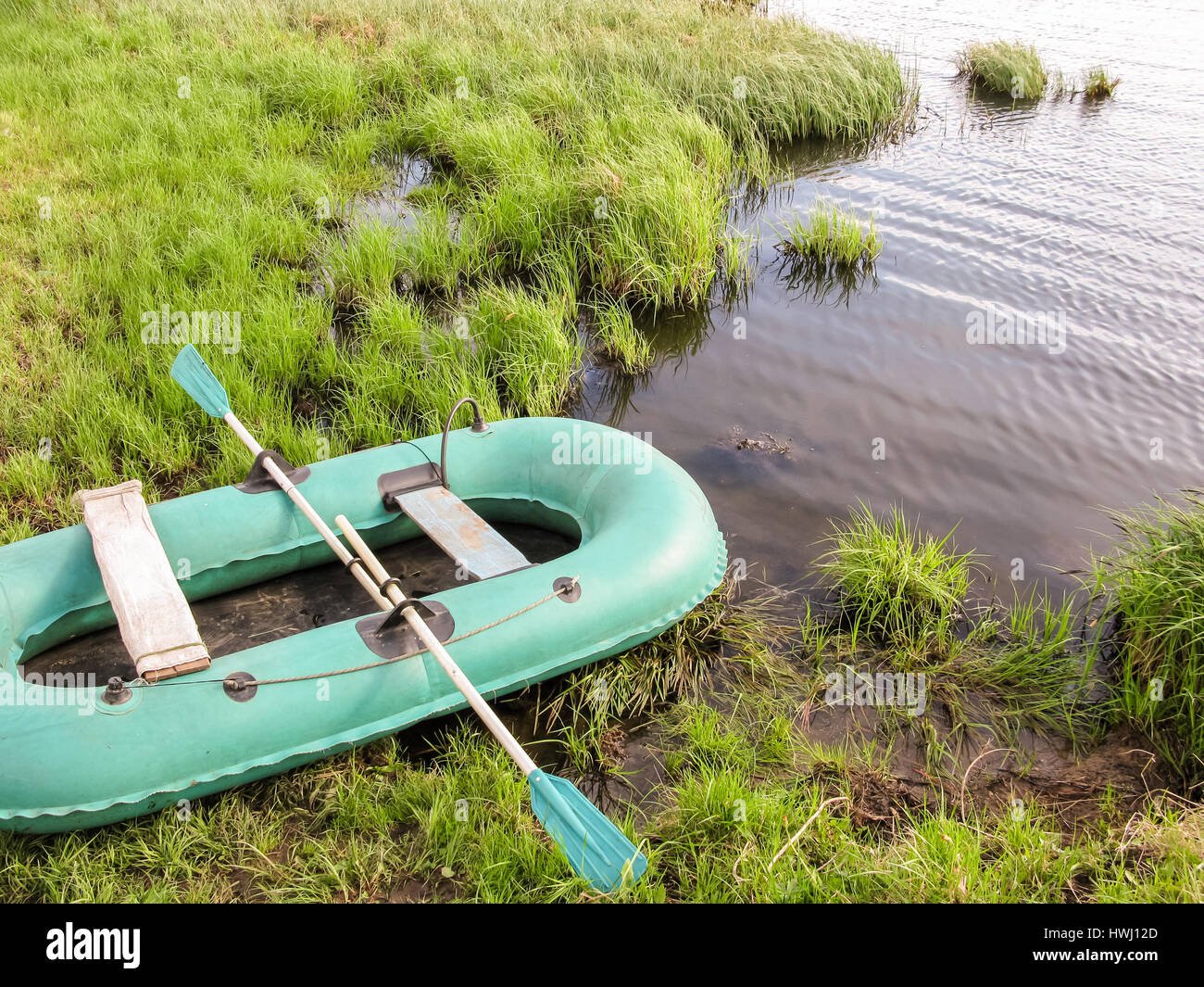 Inflatable boat on the green grass by the lake Stock Photo - Alamy
