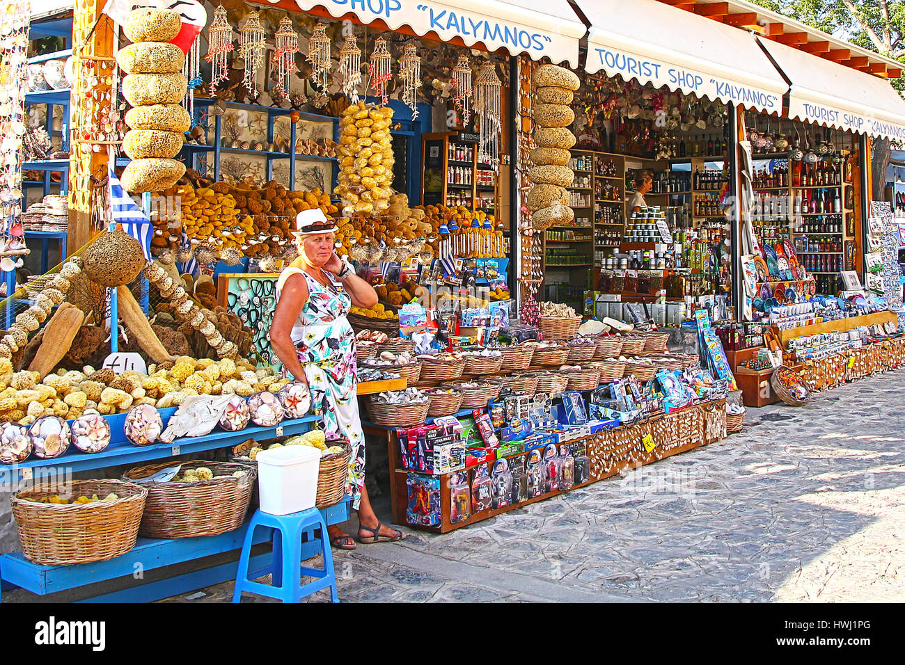 Proud Greek shopkeeper stands in front of her shop selling natural ...