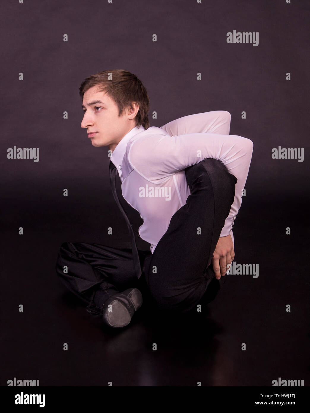 Extraordinary gymnast on a black background. The man with no bones ...