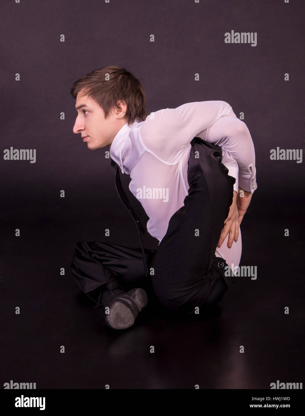 Extraordinary gymnast on a black background. The man with no bones ...