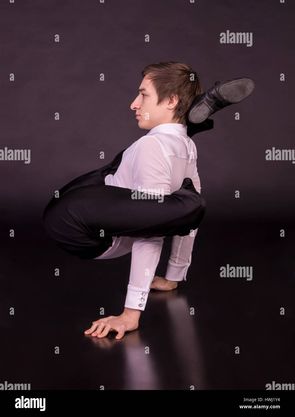 Extraordinary gymnast on a black background. The man with no bones ...