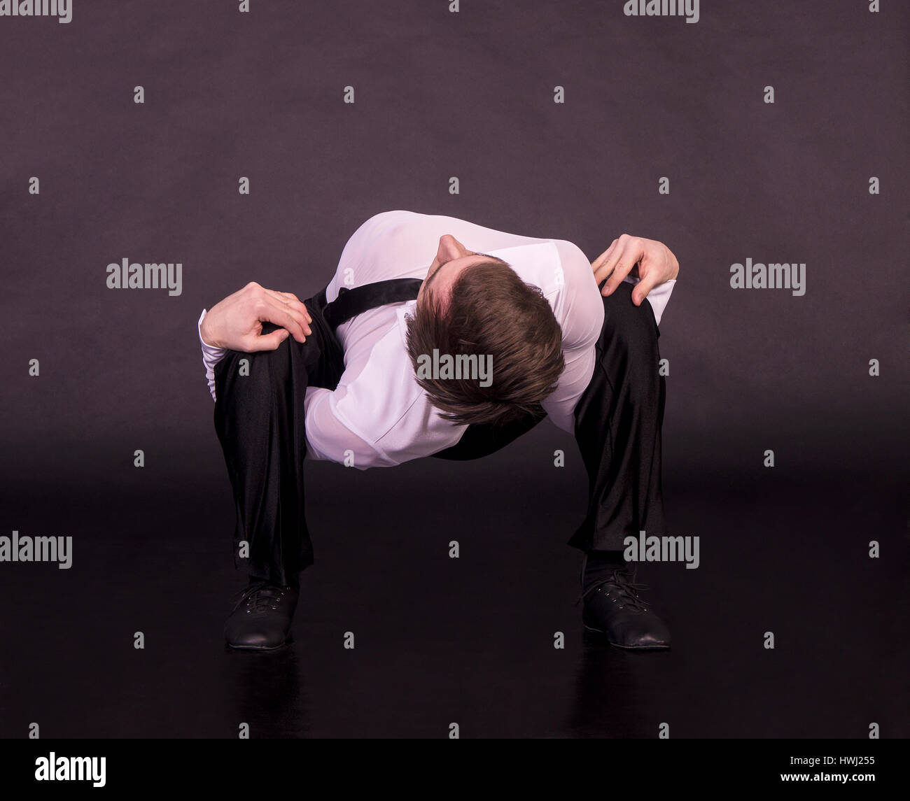 Extraordinary gymnast on a black background. The man with no bones ...