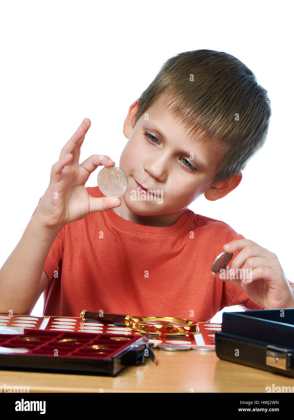 Boy examines silver coins from his collection isolated white Stock ...