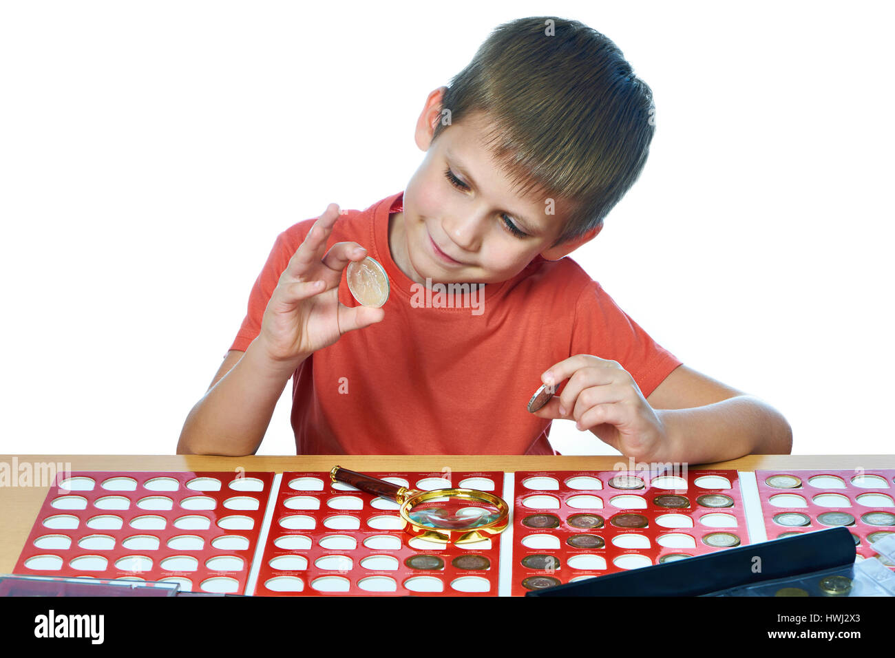 Boy examines silver coins from his collection isolated white Stock ...