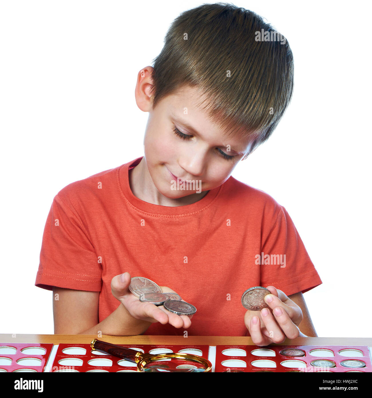 Boy examines silver coins from his collection isolated white Stock ...