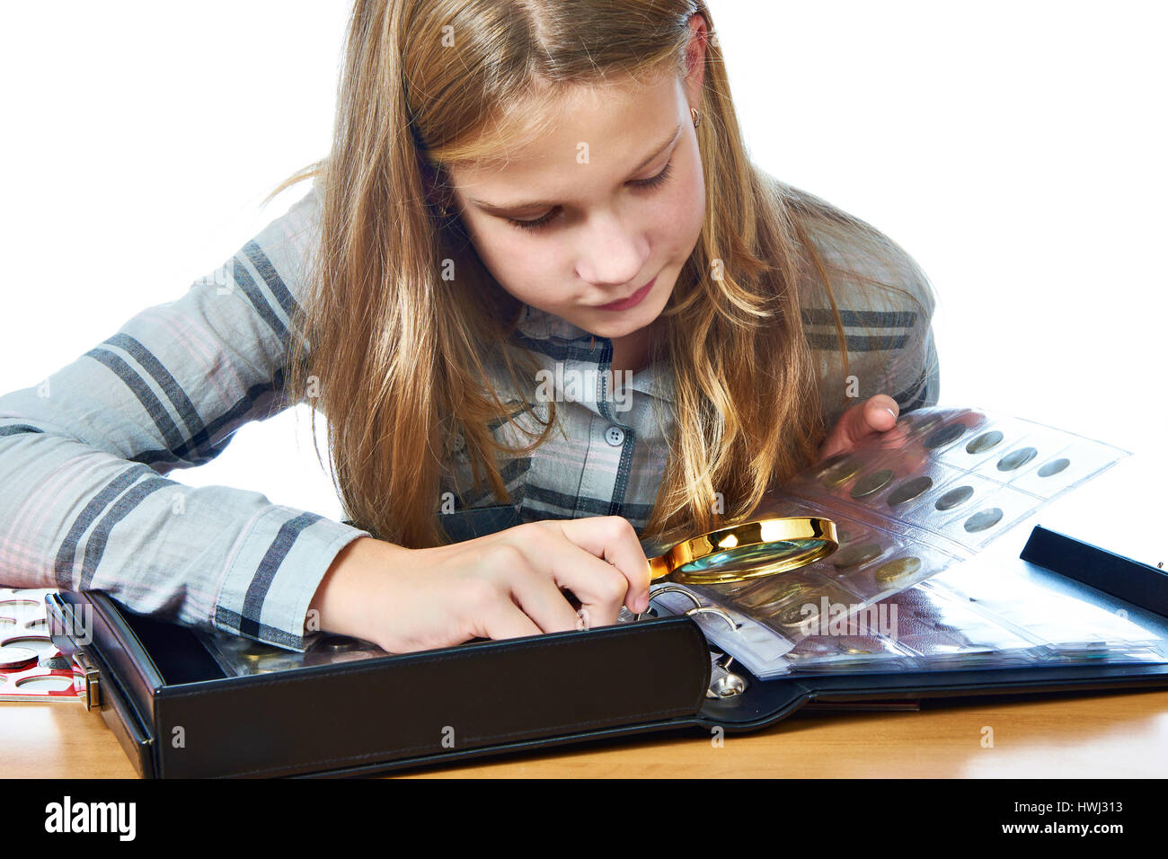 Girl inspecting her collection coins isolated white Stock Photo - Alamy