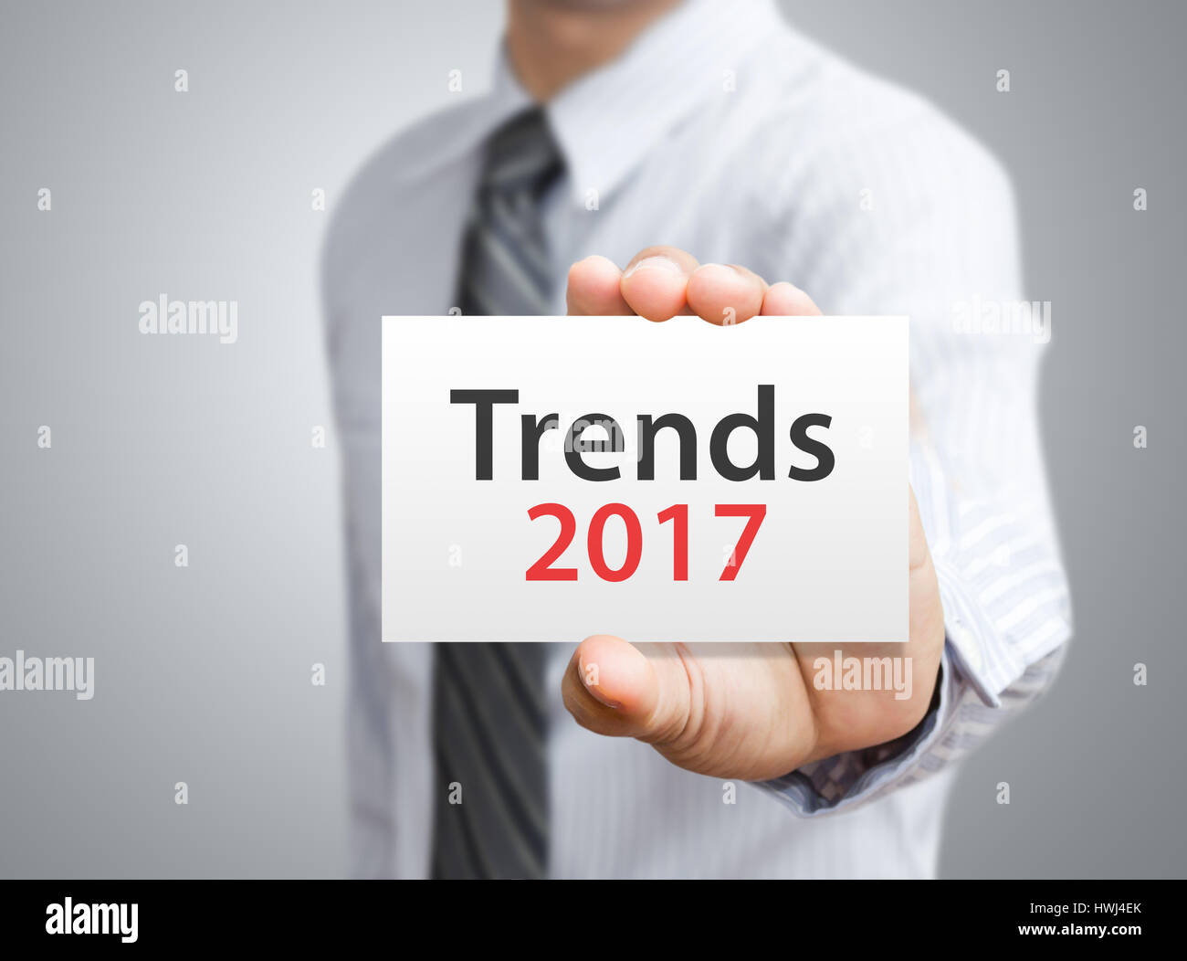 Businessman showing trends 2017 wording on white card Stock Photo - Alamy