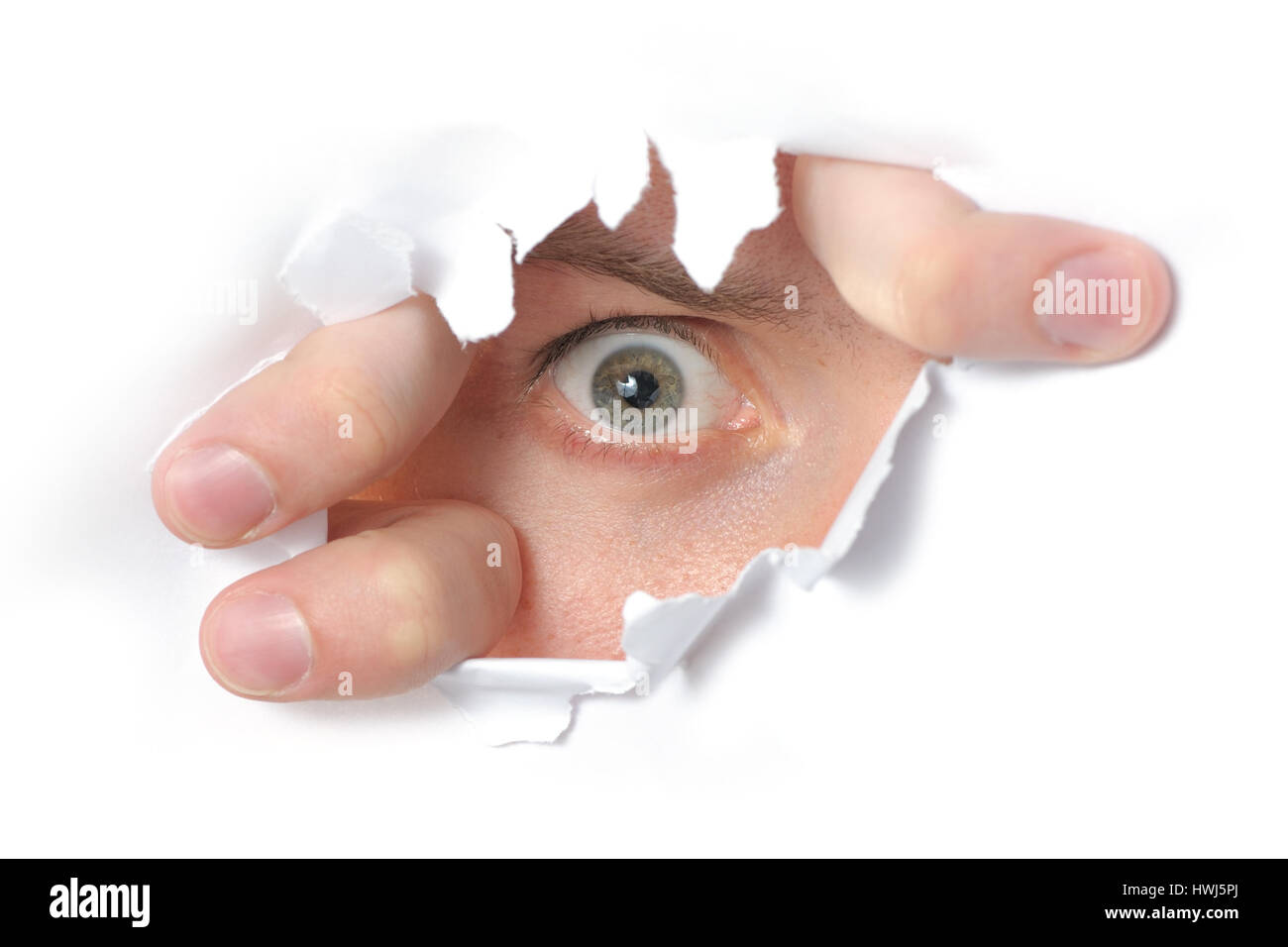 Eye looking through a hole in a paper Stock Photo - Alamy