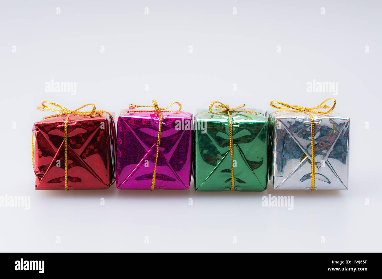 A row of gifts wrapped in shiny wrapping paper in an assortment of ...