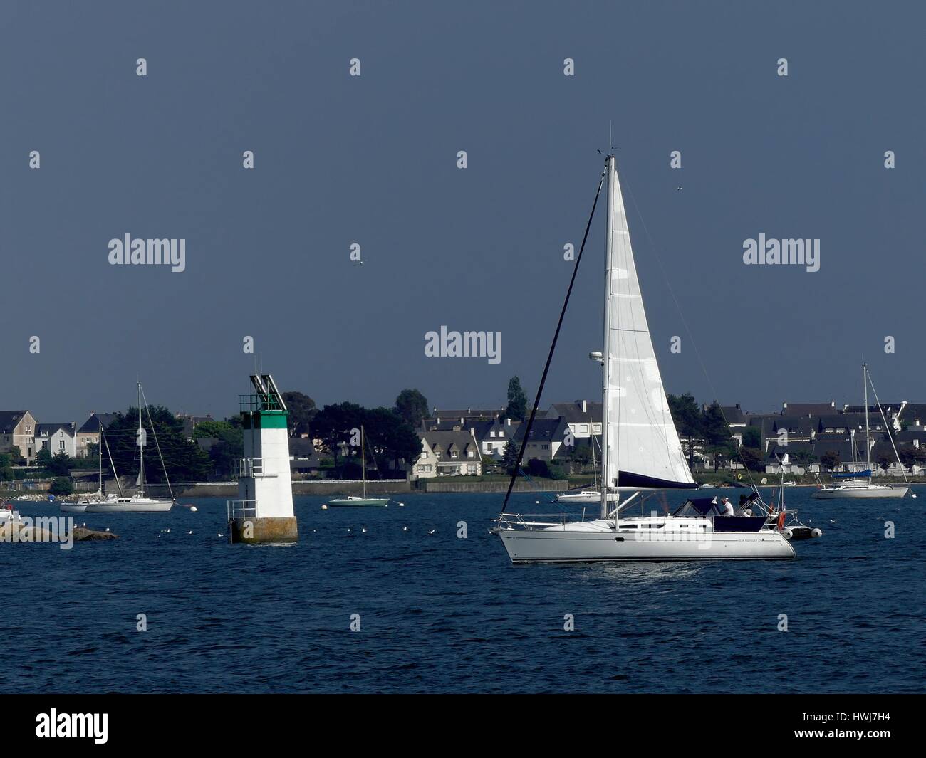 Sailing boat under main sail proceeding to the harbor Stock Photo - Alamy