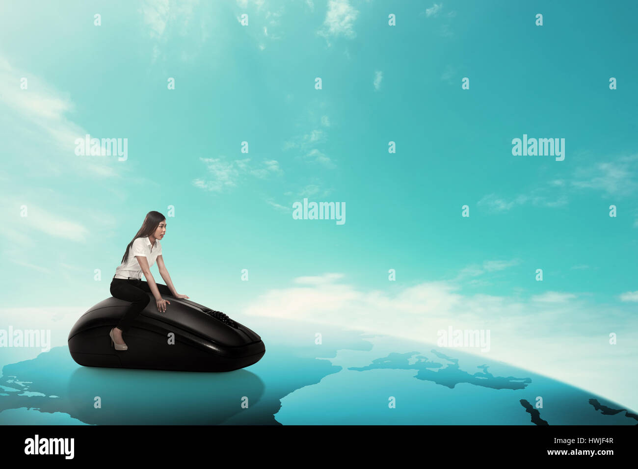 Asian business person riding computer mouse over the world map Stock ...