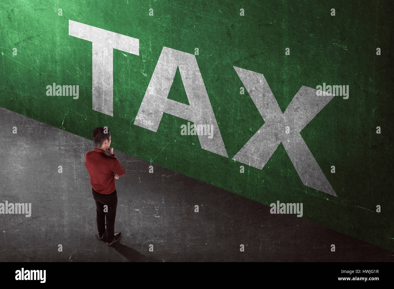 Asian business man looking tax writing on the wall Stock Photo - Alamy