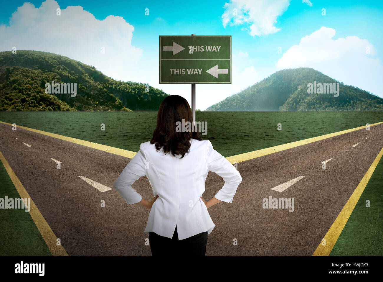 Asian woman standing in the middle of cross road thinking about ...