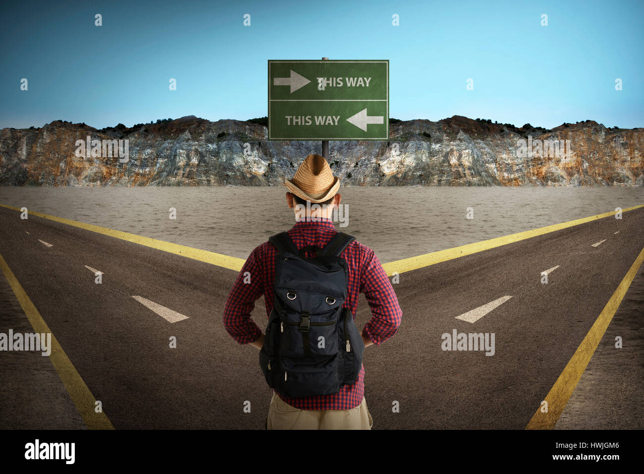 Asian tourist standing in the middle of crossroad looking for direction ...