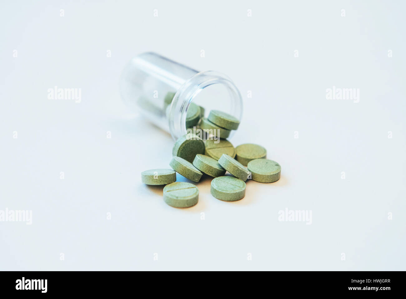 Medical green pills for treatment and health care on a white background ...