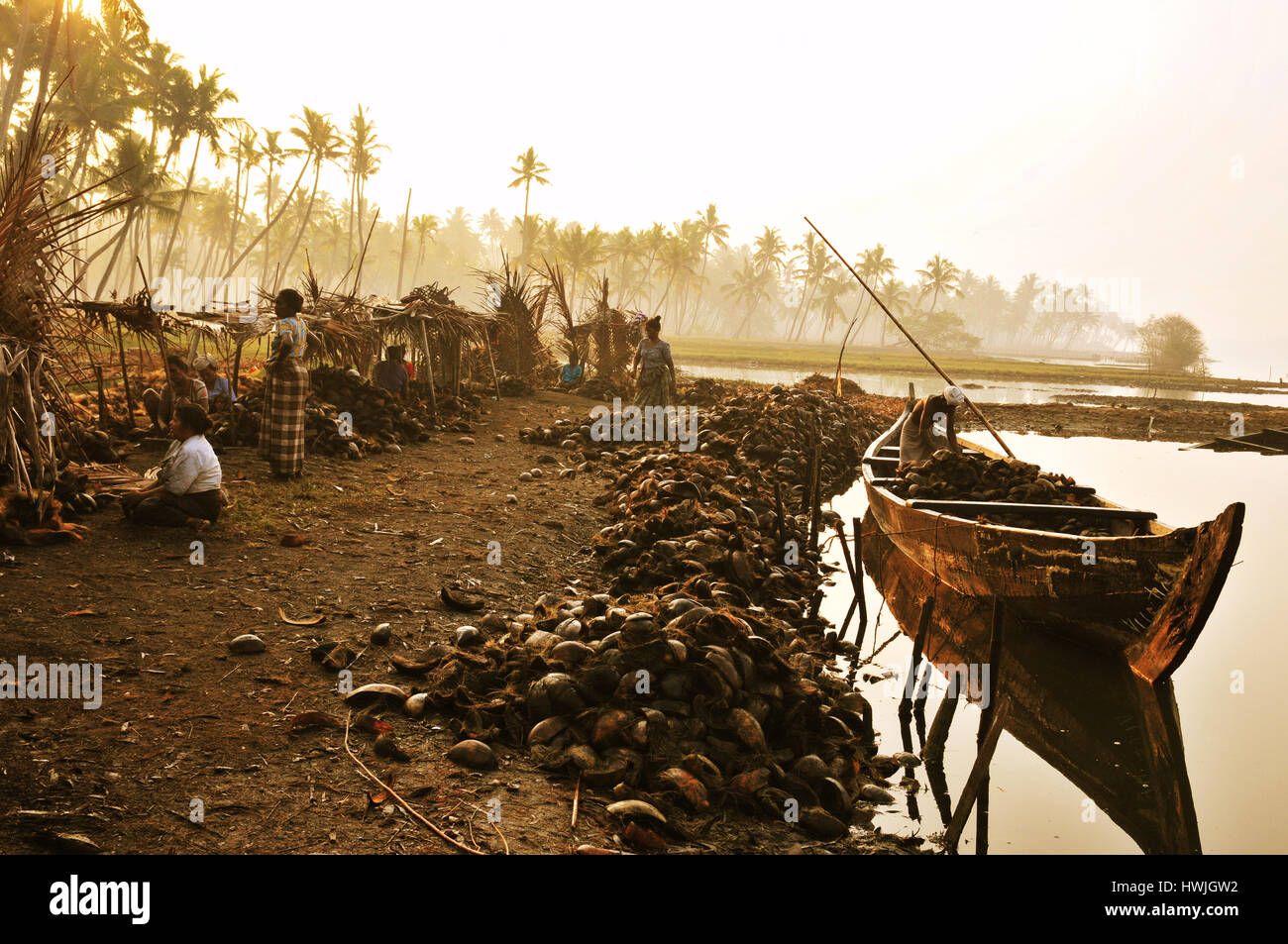 A worker off loading wet-milled coconut husk to waitting ladies, they ...