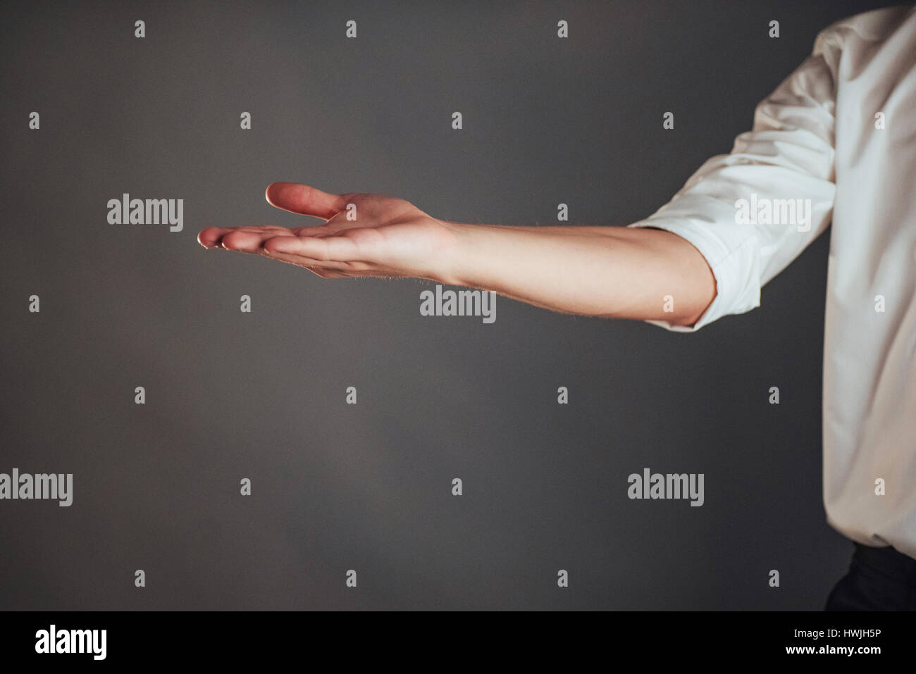 Young businessman showing empty hands, ready to fill with your design ...