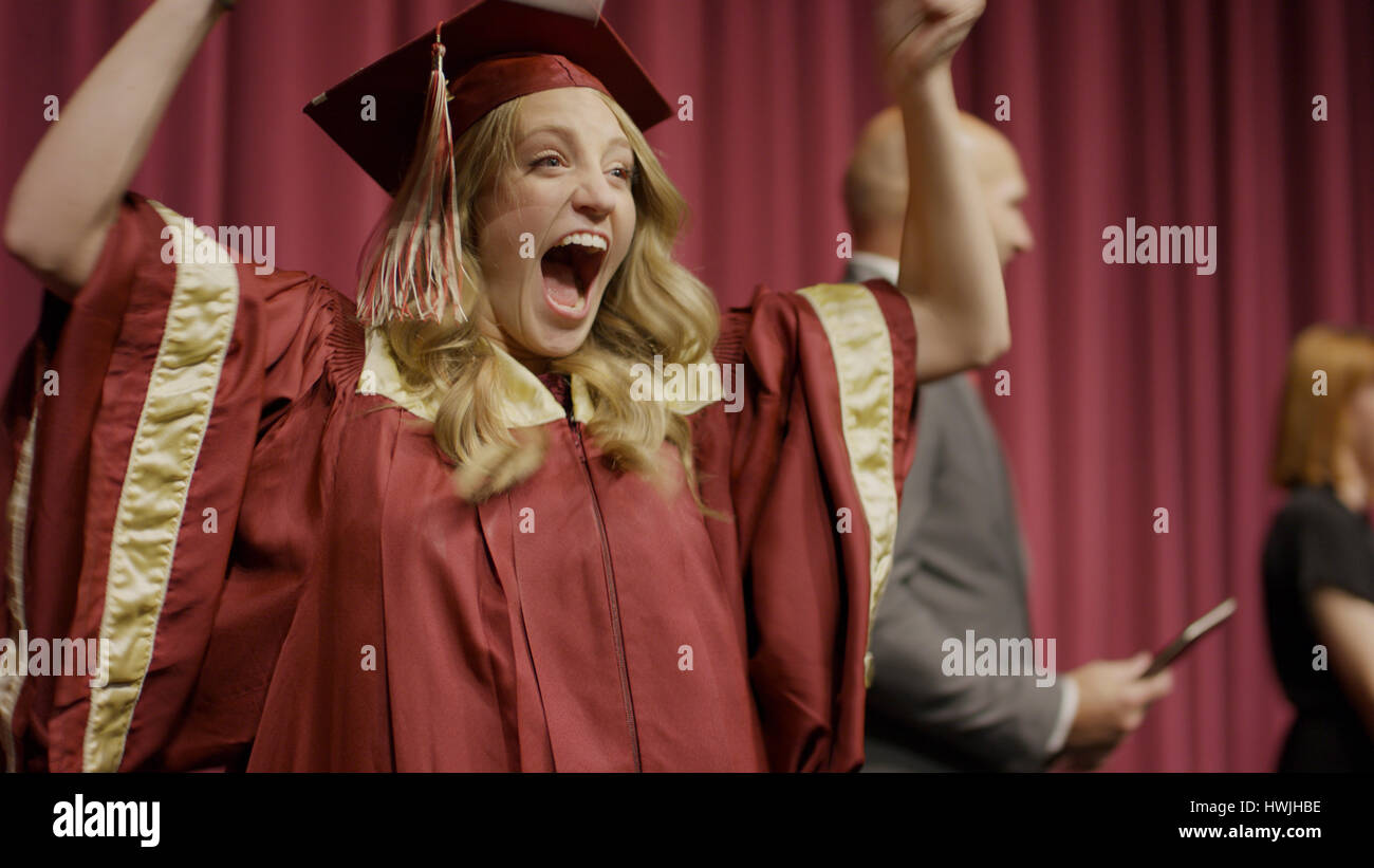 Blurred view of cheering student on stage during graduation ceremony ...