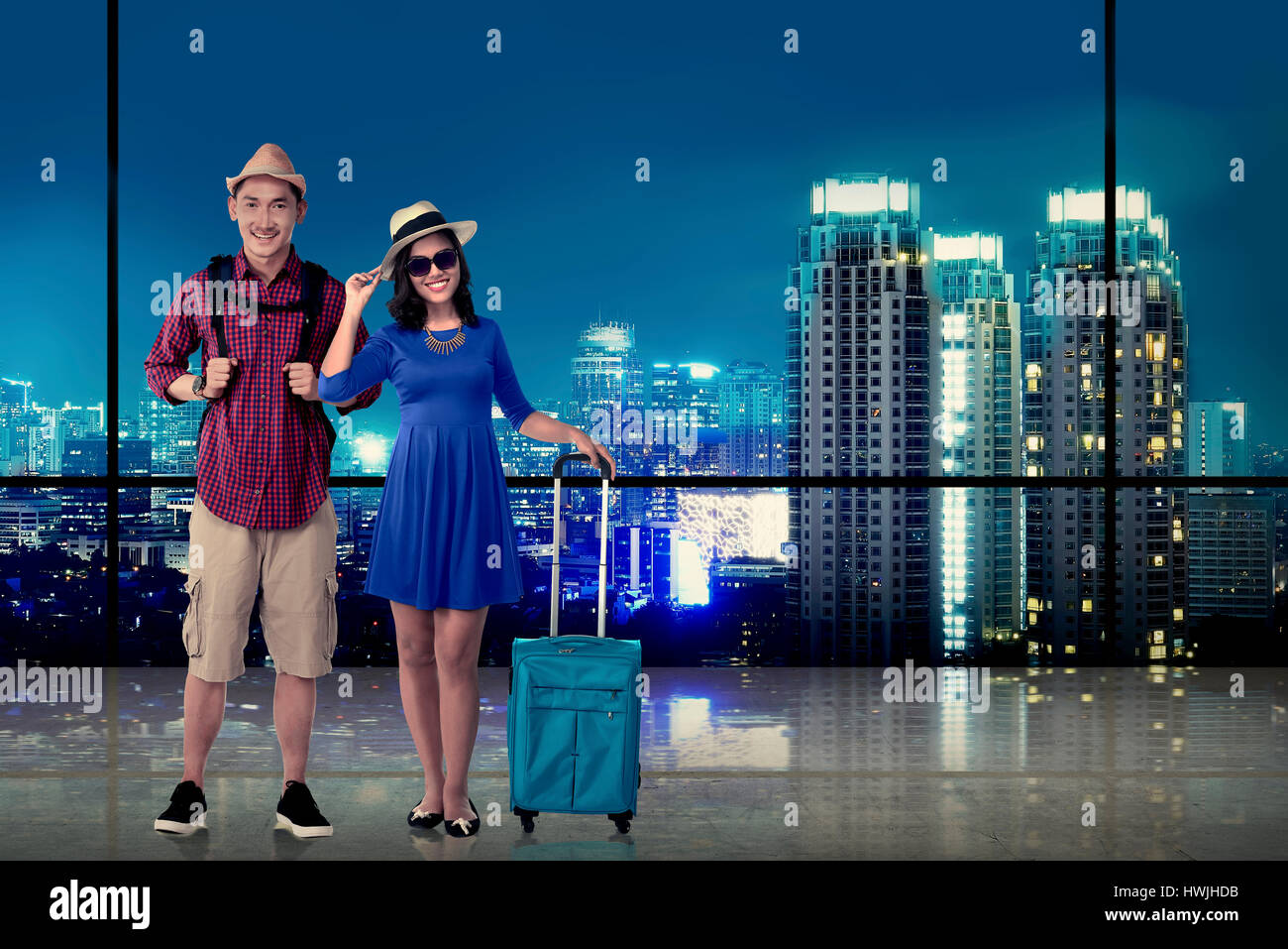 Asian couple tourist posing over city background Stock Photo - Alamy