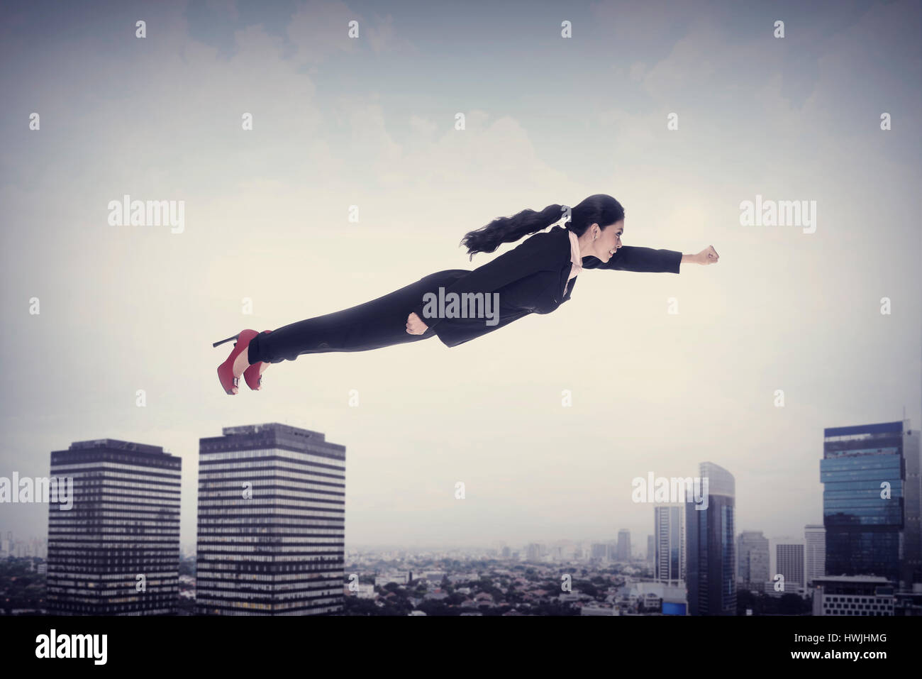 Asian business woman flying over the city Stock Photo - Alamy