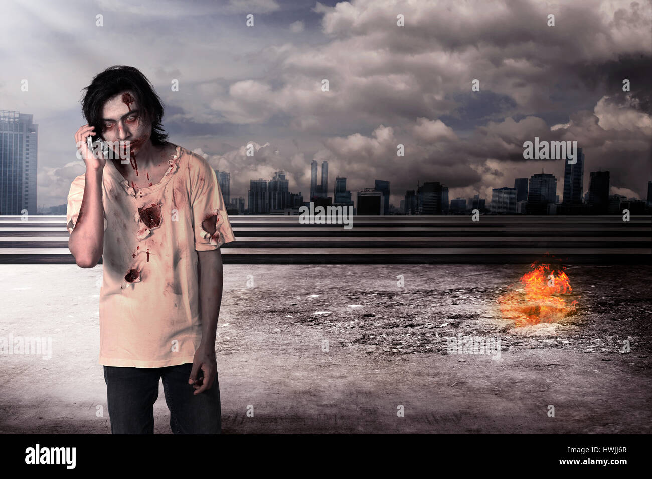 Male zombie call via cellphone with city on fire background Stock Photo ...