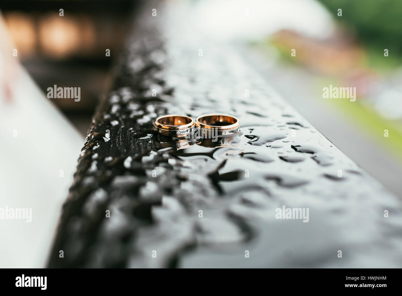 Beautiful golden wedding rings between drops Stock Photo - Alamy