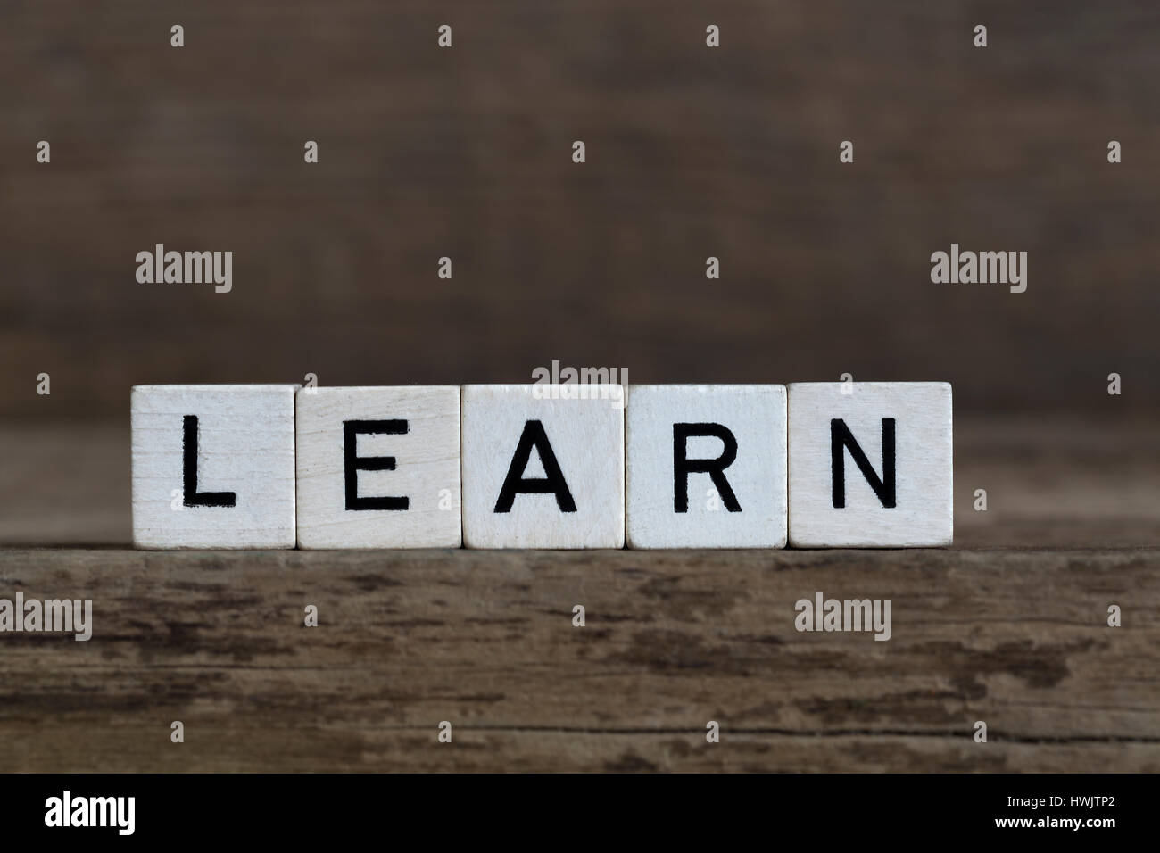 Learn, written in cubes on a wooden background Stock Photo - Alamy