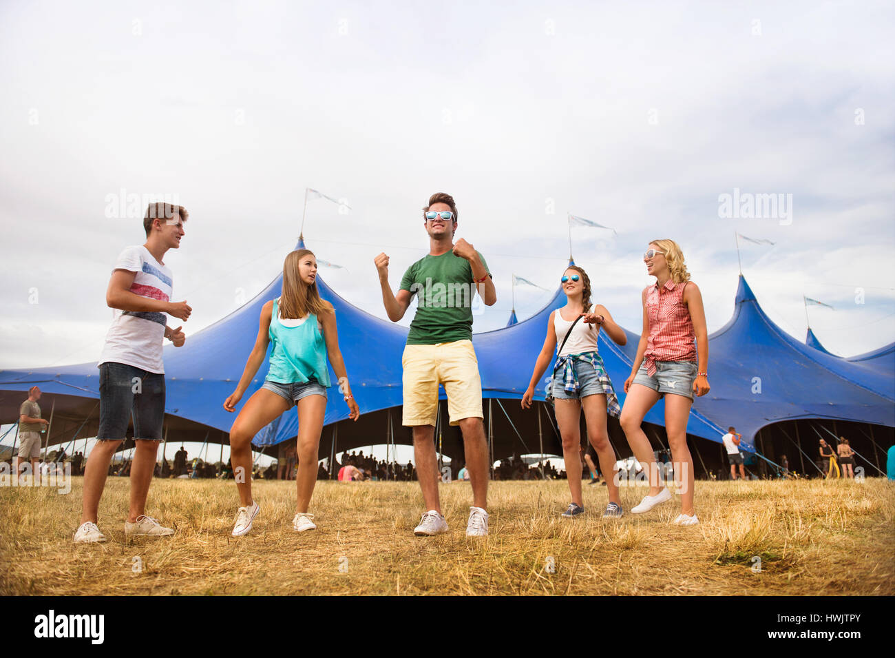 Group of teenage boys and girls at summer music festival, dancing in ...