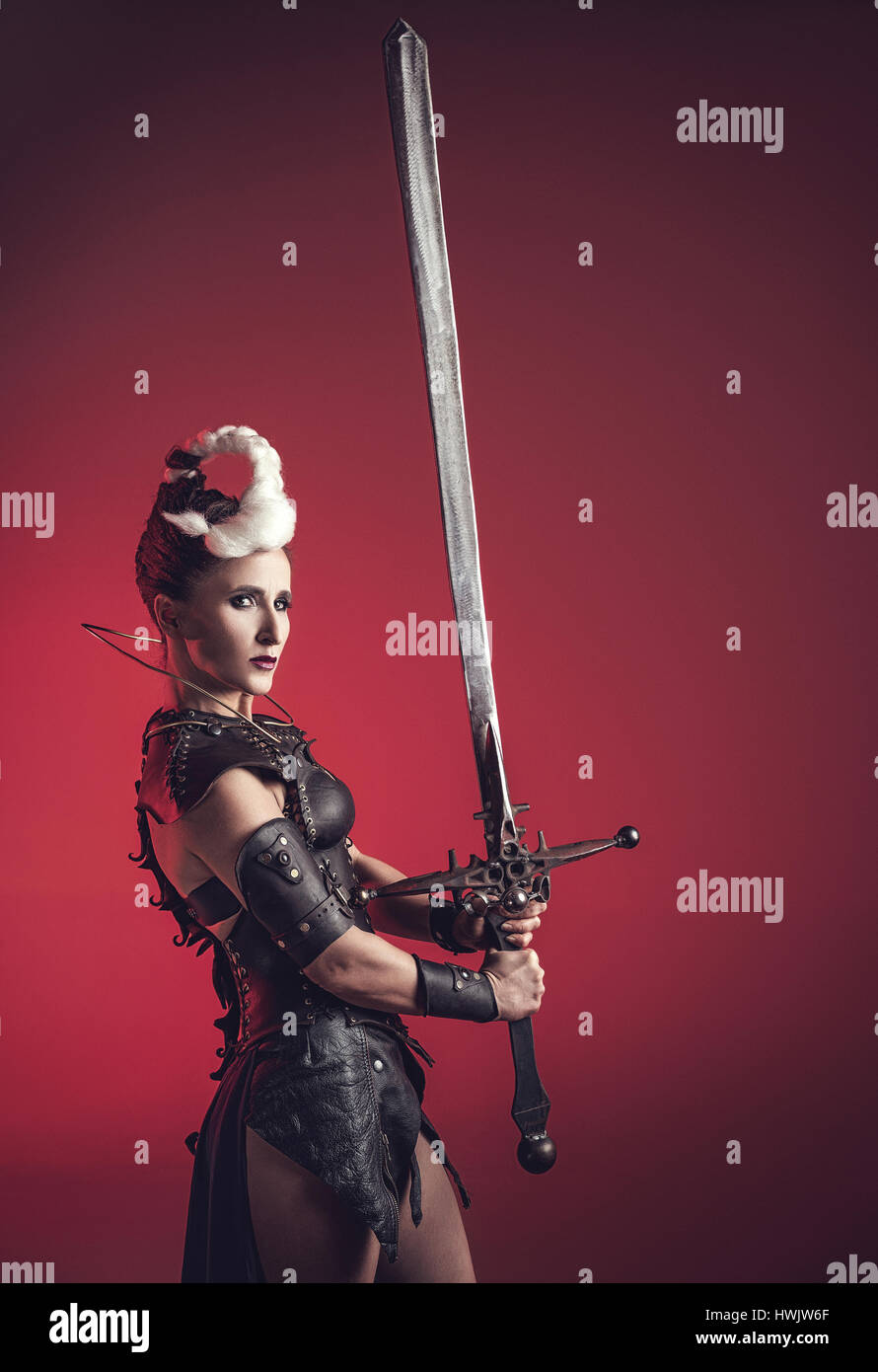 Beautiful warrior woman. Fantasy fighter. Princess or queen in leather corset ready for war. Red ...