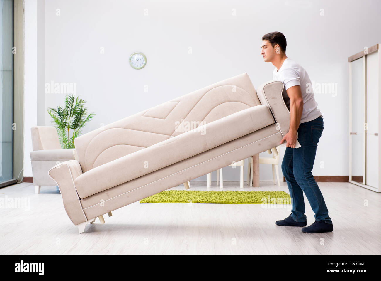Young man moving furniture at home Stock Photo - Alamy