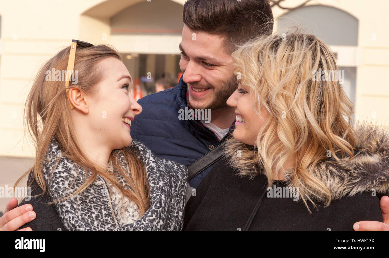 three young people happily smiling in city environment Stock Photo - Alamy