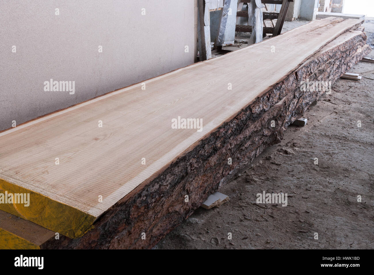 Stacked on top of each other larch slabs with bark and colored ends ...