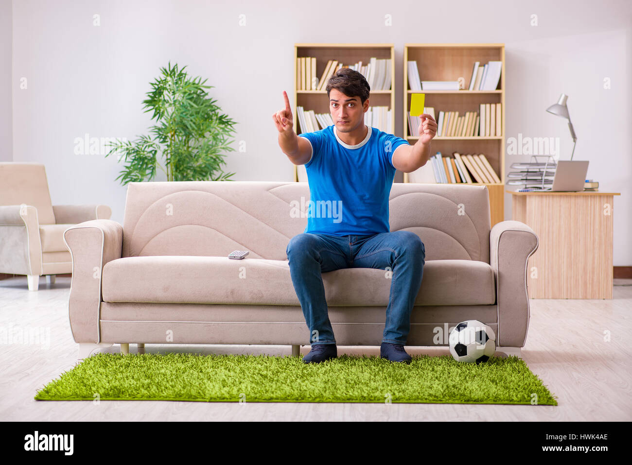 Man watching football at home sitting in couch Stock Photo - Alamy