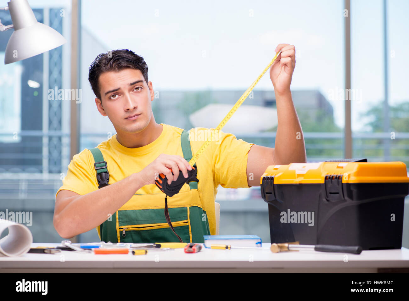 Construction worker sitting at the desk Stock Photo - Alamy
