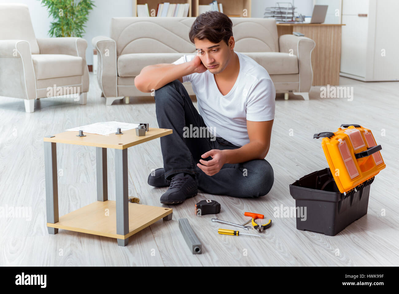 Man assembling furniture at home Stock Photo - Alamy