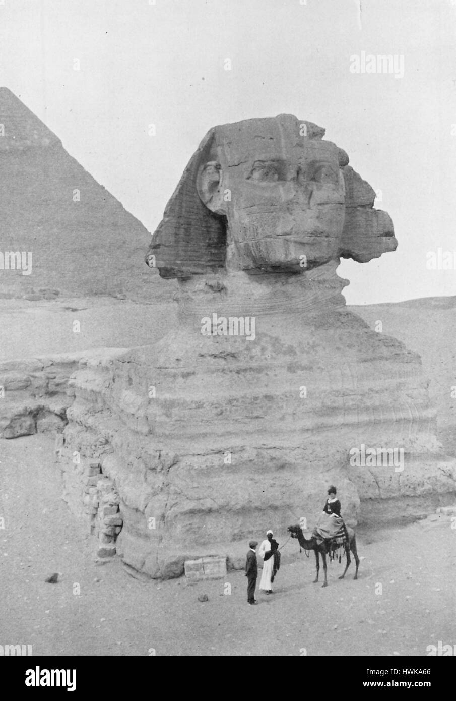 Western visitors take a camel ride under the Great Sphinx of Giza ...