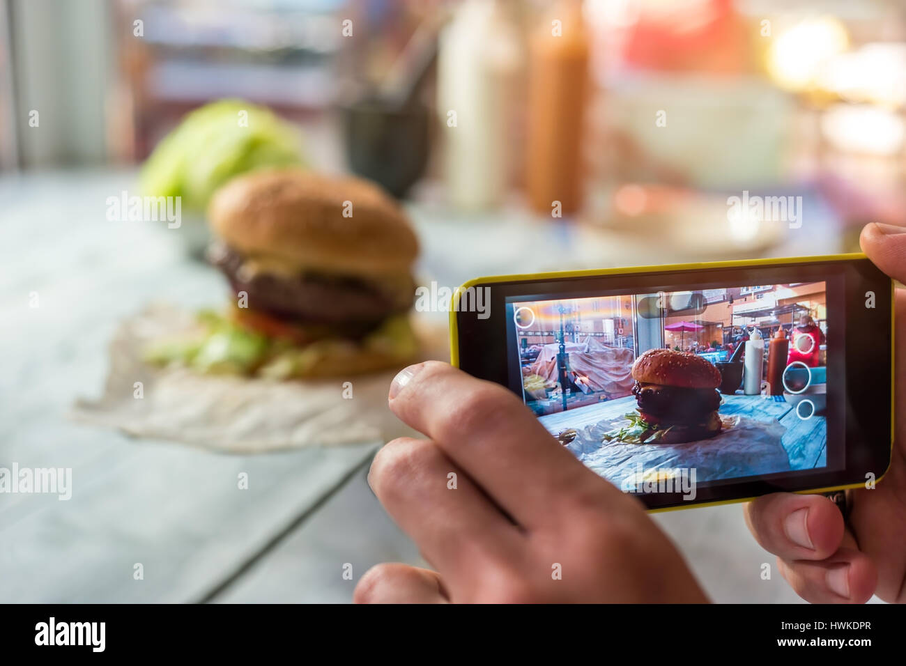 Cell phone photographing a burger Stock Photo - Alamy