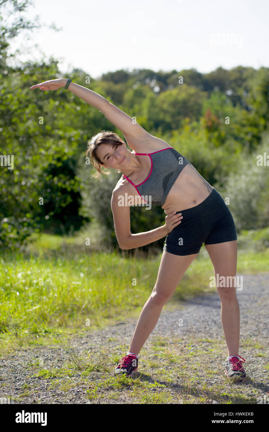 beautiful young fitness woman doing exercise in countryside Stock Photo ...