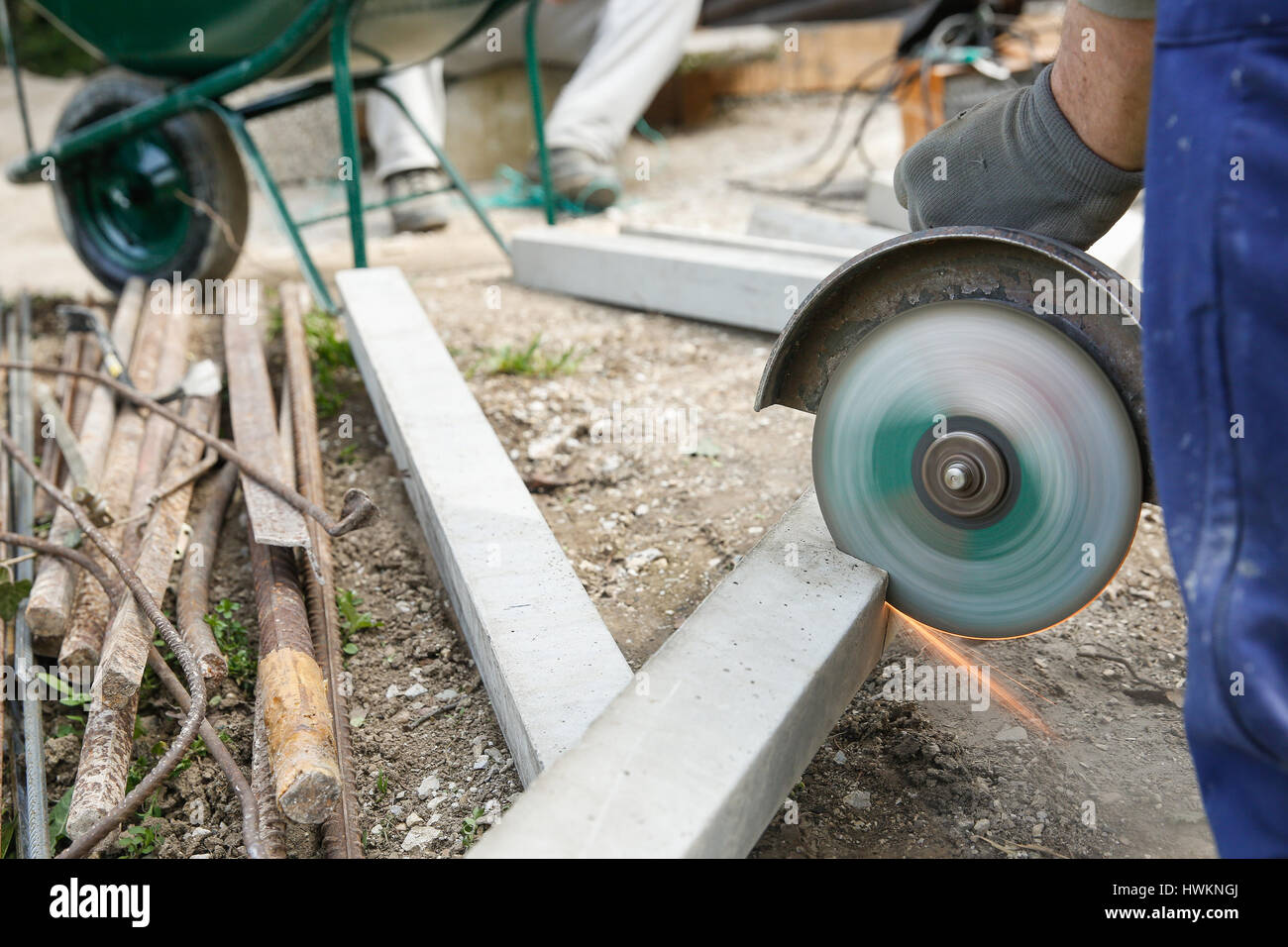 Construction worker cutting a reinforced concrete pillar for ...