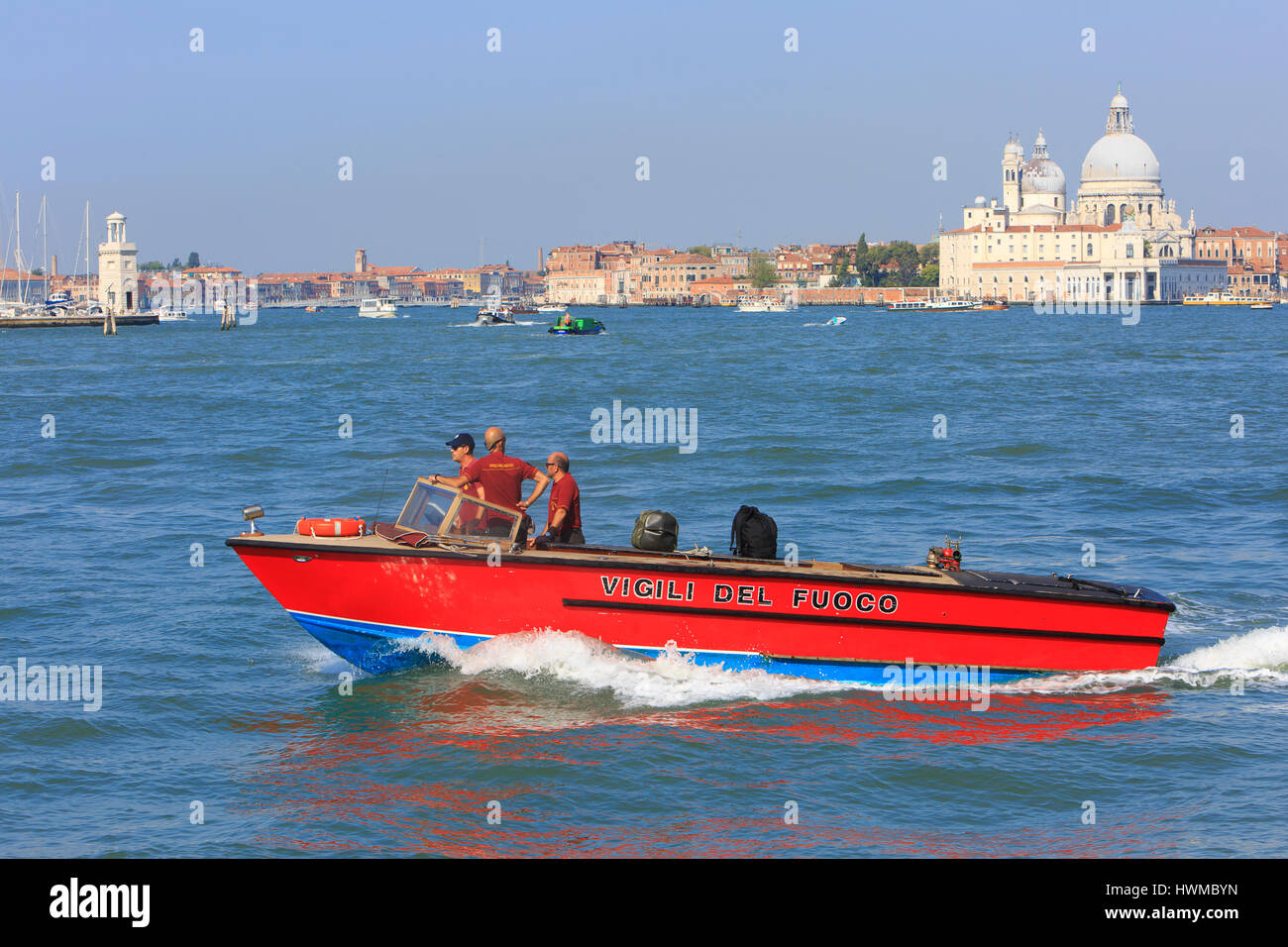 The Venetian fire brigade speeding in a red motorboat across the laguna ...