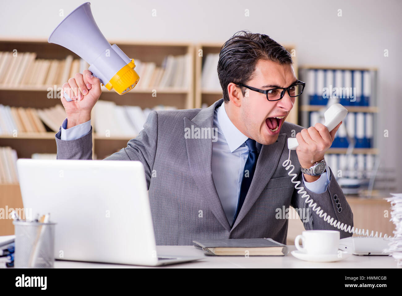 Angry businessman with too much work in office Stock Photo - Alamy