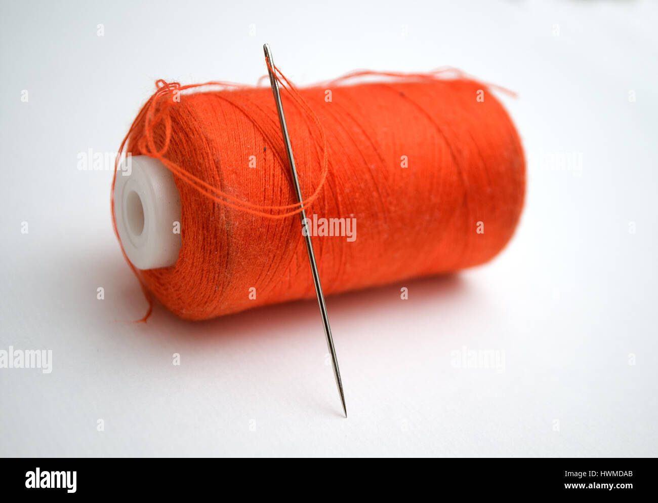 The orange thread with a needle Stock Photo - Alamy