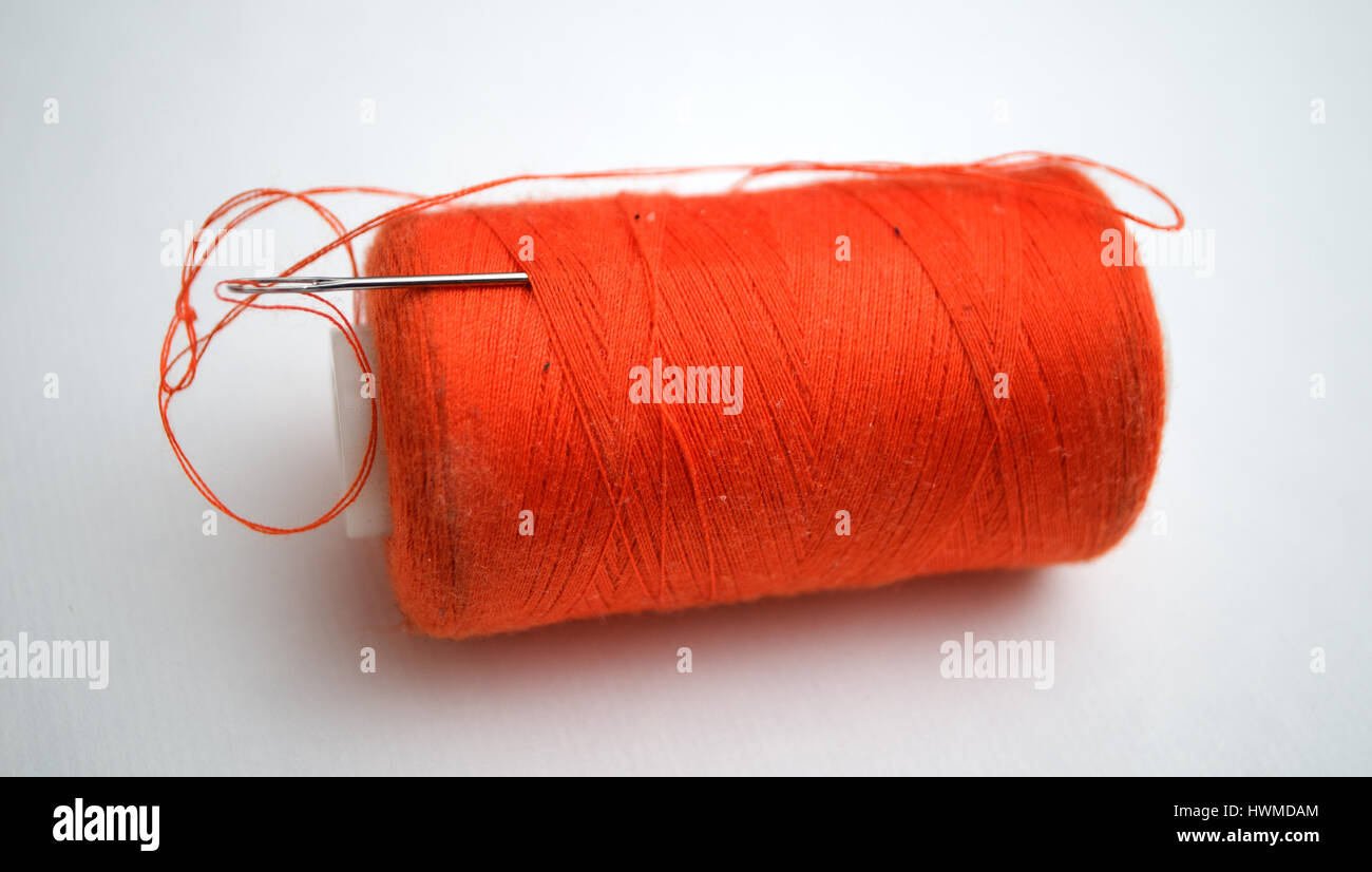 The orange thread with a needle Stock Photo - Alamy