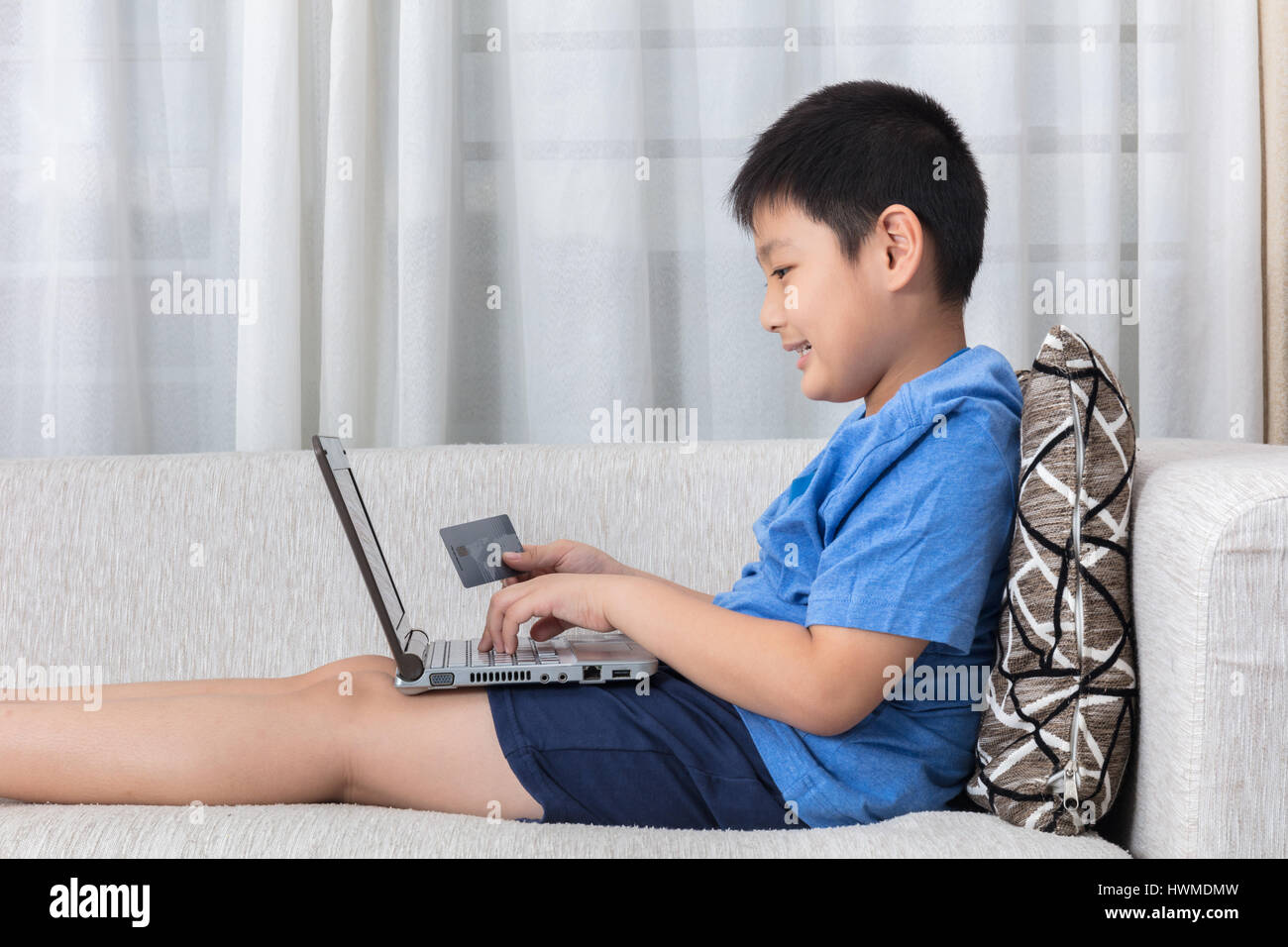 Happy Asian Chinese little boy using laptop with credit card in the ...