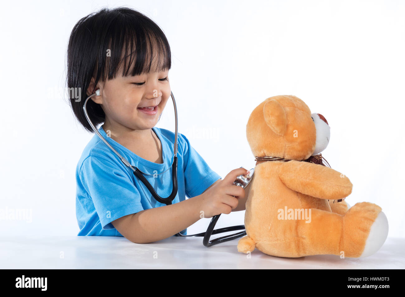 Happy Asian Chinese little doctor girl examine teddy bear in isolated ...