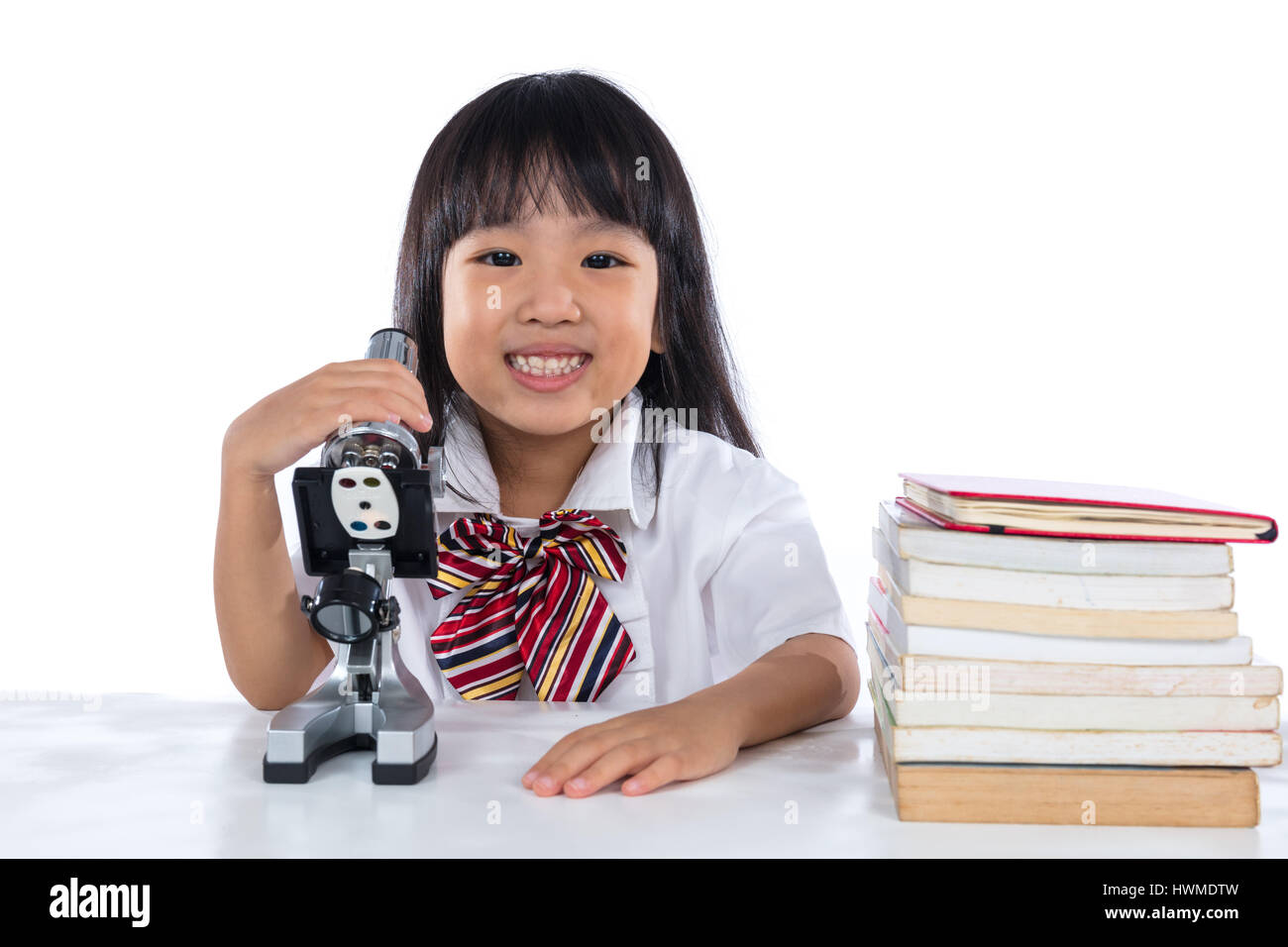 Happy Asian Chinese little girl with microscope and books in isolated ...