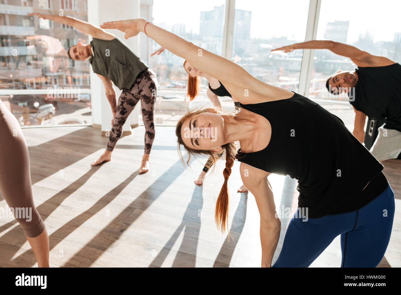 Group of people making exercises and stretching in yoga class Stock ...