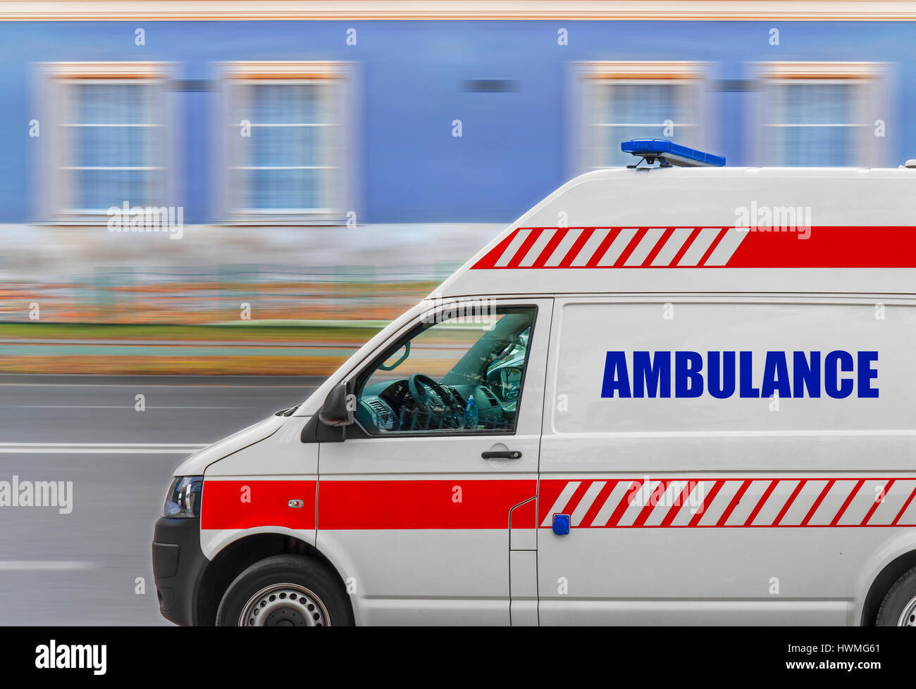 Ambulance service van driving fast on street Stock Photo - Alamy