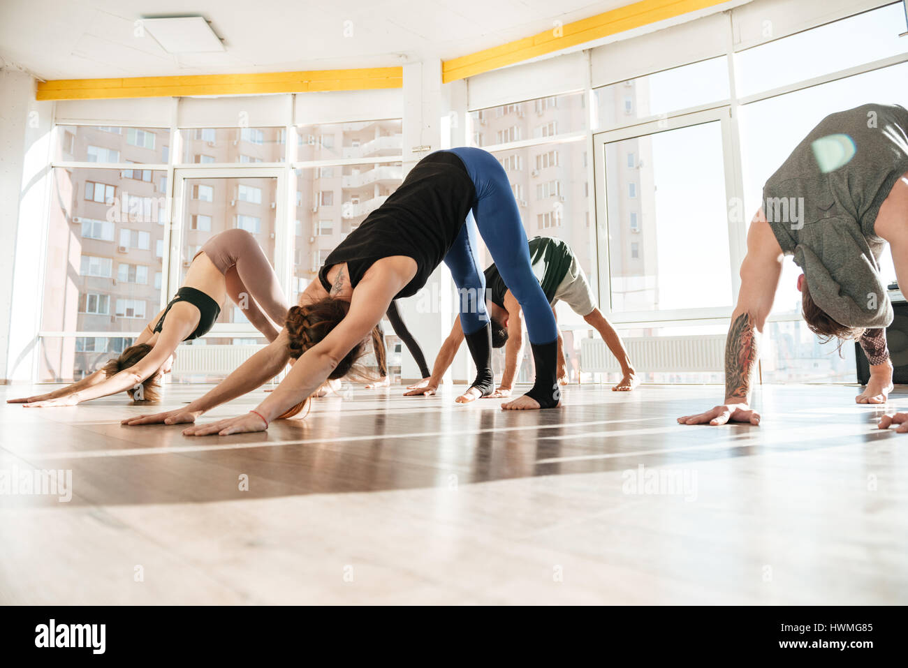 Group of people standing and practicing yoga in studio Stock Photo - Alamy